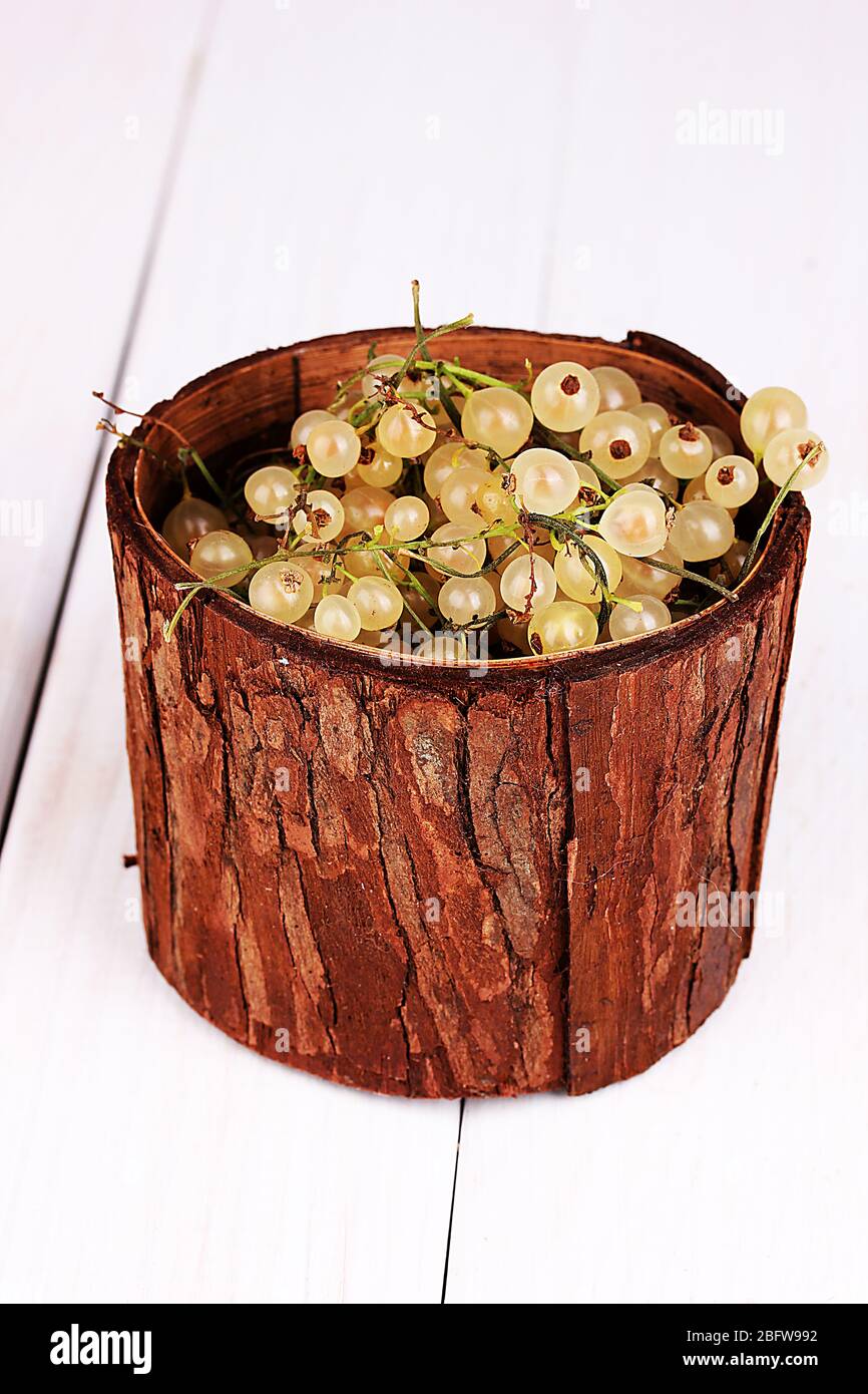White currants in wooden cup on wooden background Stock Photo - Alamy