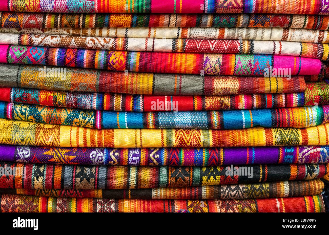 A pile of colorful Andean fabrics on the poncho market of Otavalo ...