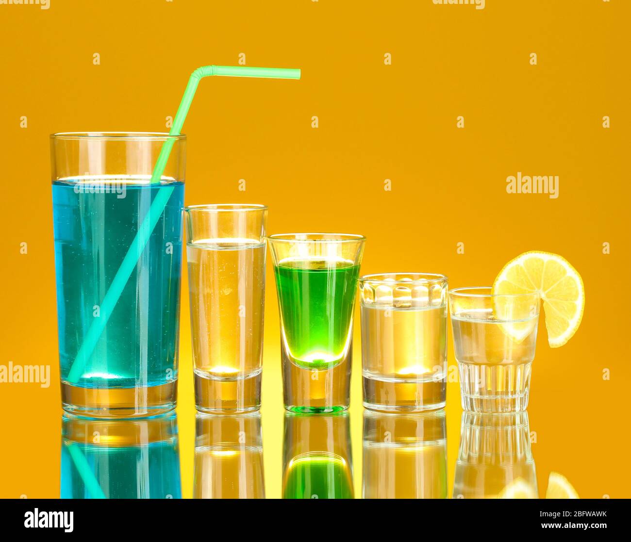a variety of alcoholic drinks on yellow background Stock Photo - Alamy