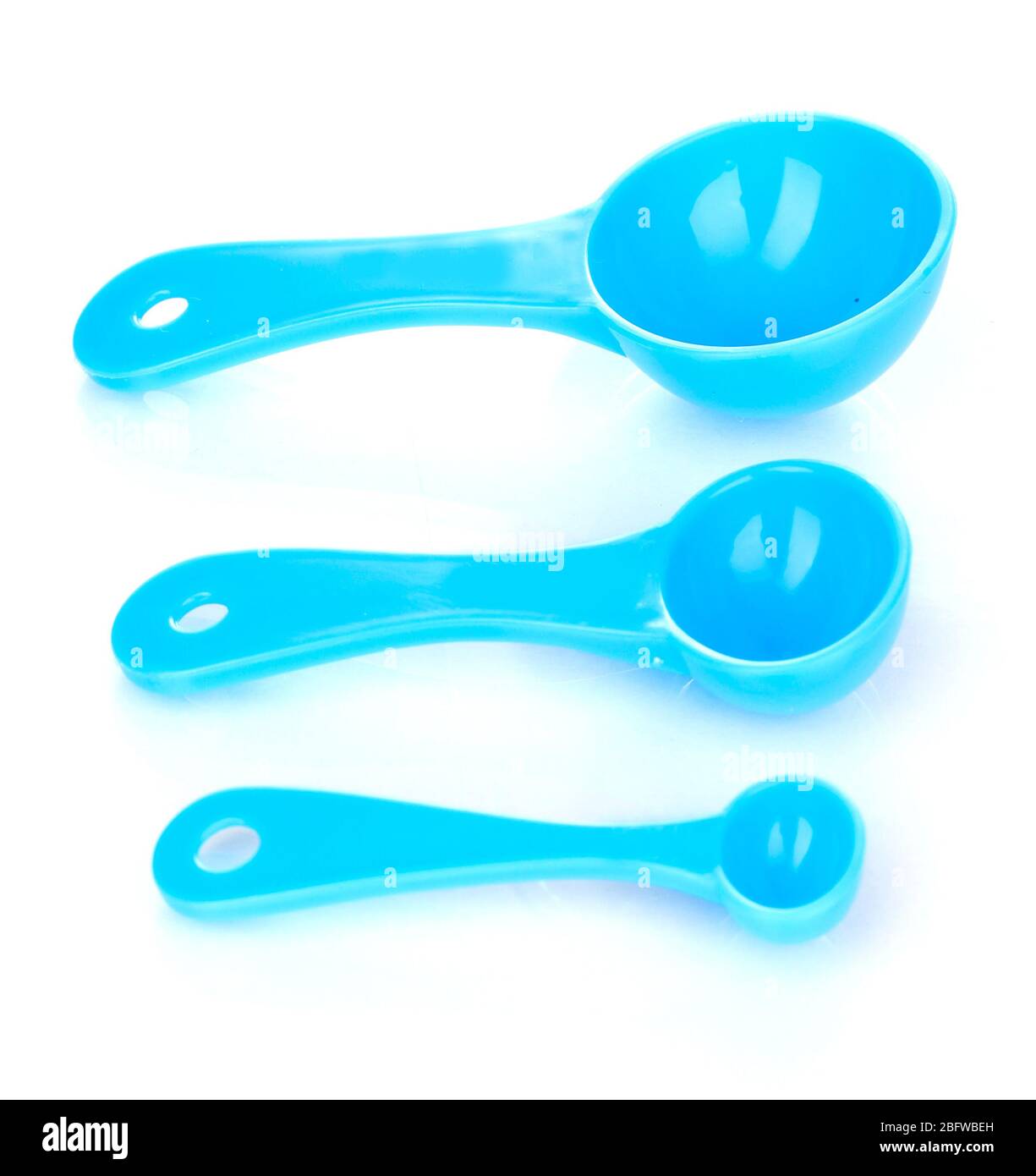 Blue measuring spoons isolated on white Stock Photo - Alamy