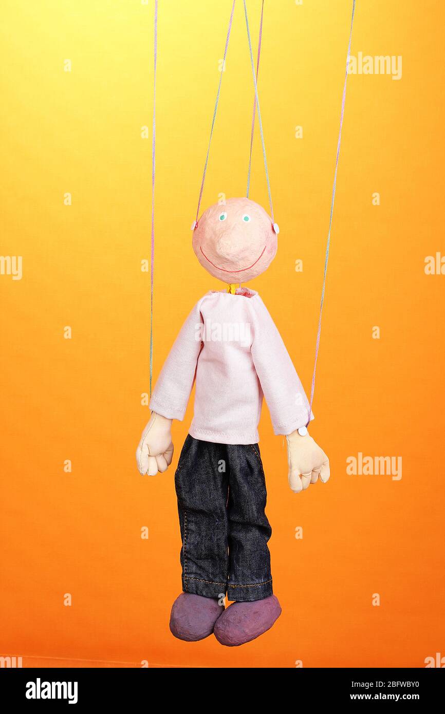 Wooden puppet on orange background Stock Photo - Alamy