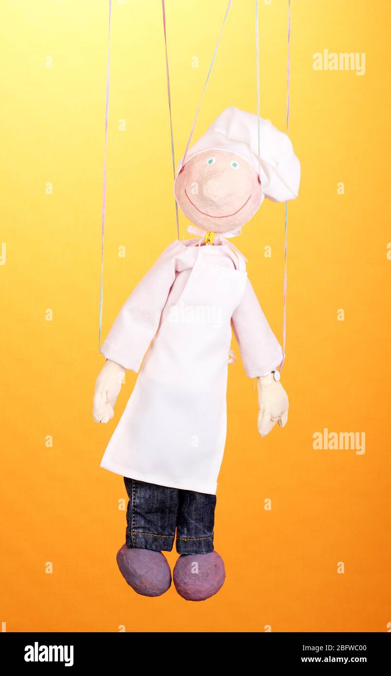 Wooden puppet as cook on orange background Stock Photo - Alamy