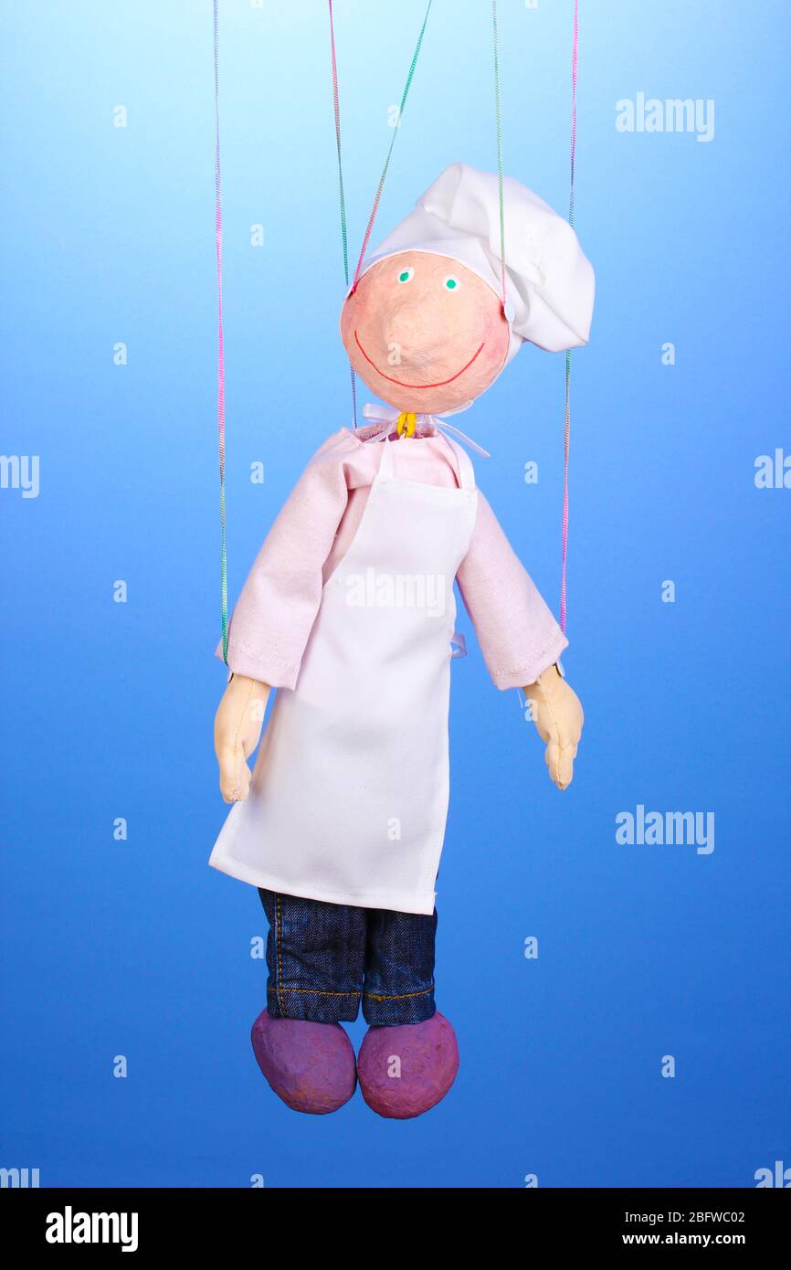 Wooden puppet as cook on blue background Stock Photo - Alamy