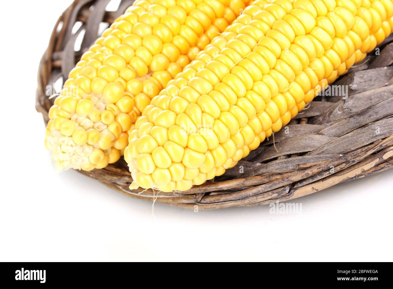 Fresh corn cobs on wicker mat isolated on white Stock Photo - Alamy