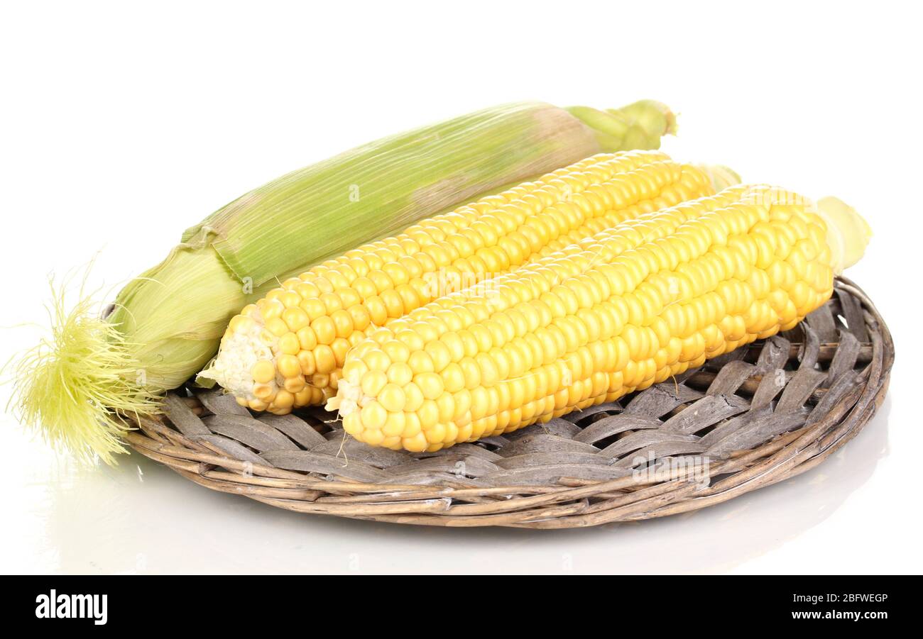 Fresh corn cobs on wicker mat isolated on white Stock Photo - Alamy