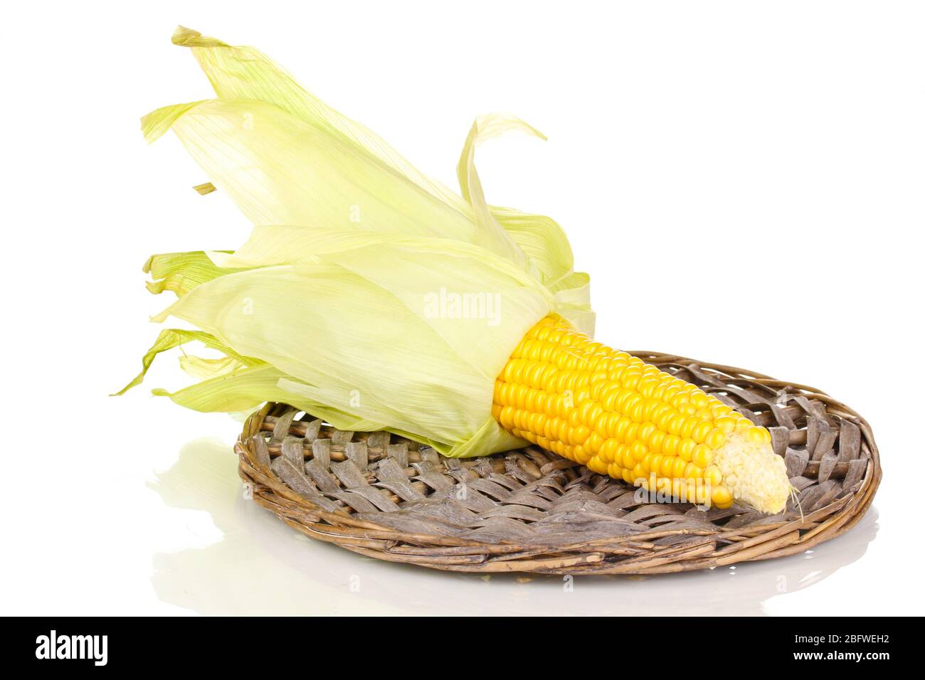 Fresh corn cob on wicker mat isolated on white Stock Photo - Alamy