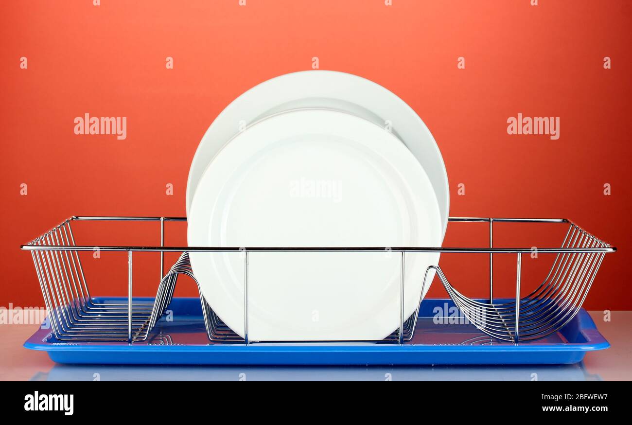 clean dishes on stand on red background Stock Photo - Alamy