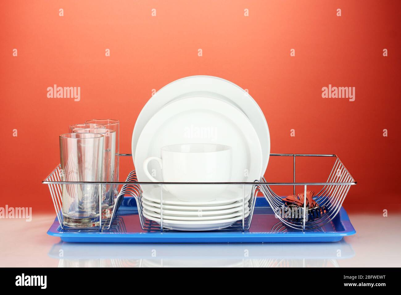 clean dishes on stand on red background Stock Photo - Alamy