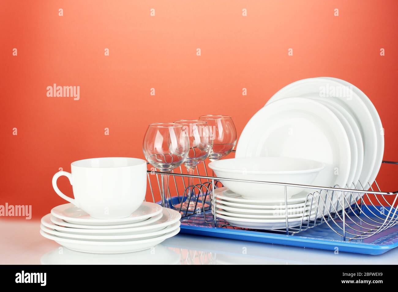clean dishes on stand on red background Stock Photo - Alamy