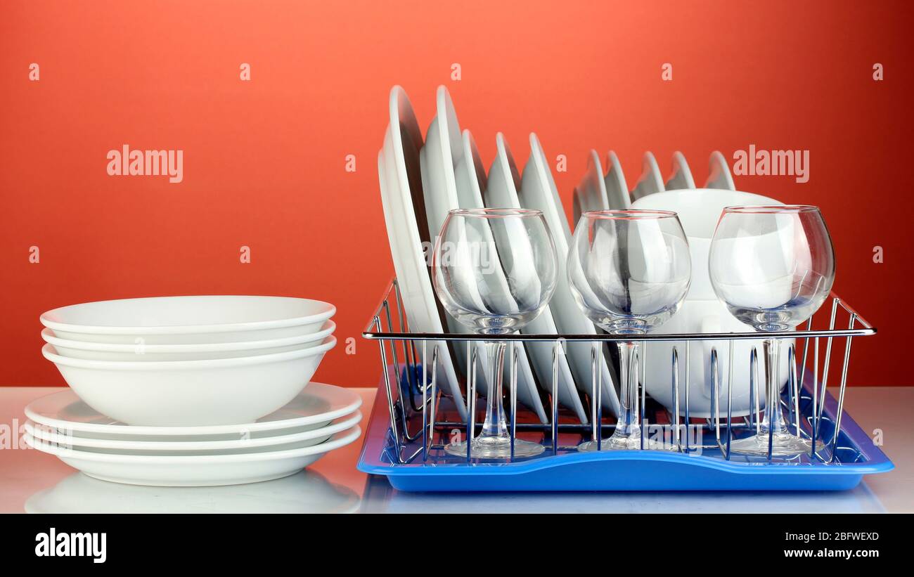 clean dishes on stand on red background Stock Photo - Alamy