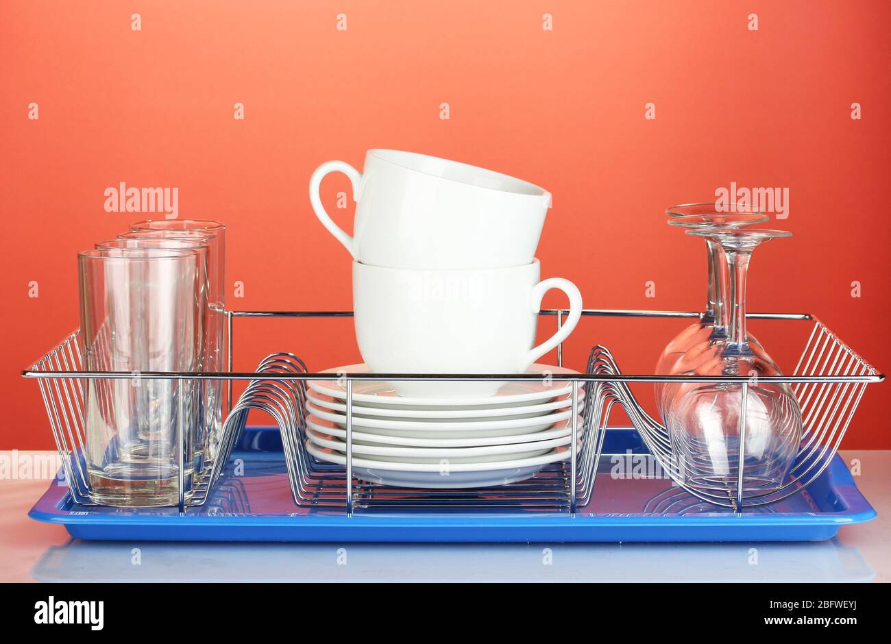 clean dishes on stand on red background Stock Photo - Alamy