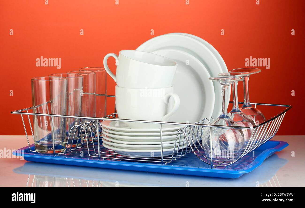 clean dishes on stand on red background Stock Photo - Alamy