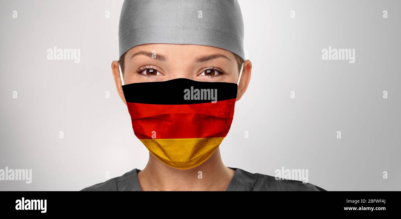 German flag on Asian doctor woman wearing mask. COVID-19 outbreak in ...