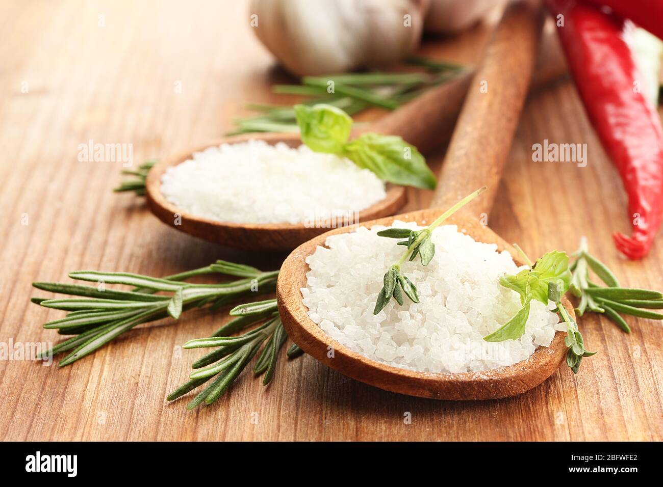 salt in spoons with herbs and vegetables isolated on white Stock Photo ...
