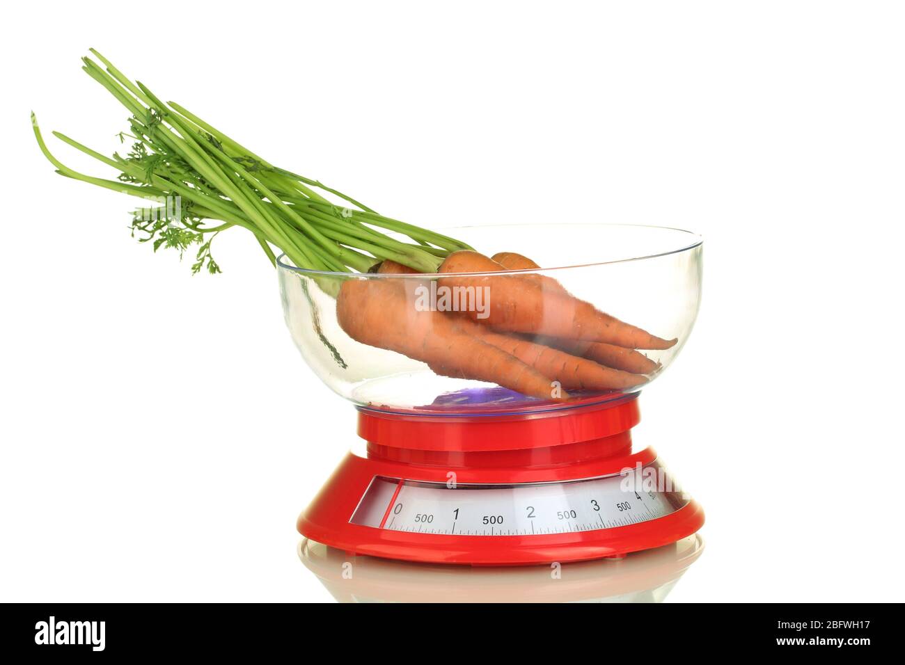 fresh carrots in a kitchen scales isolated on white Stock Photo - Alamy