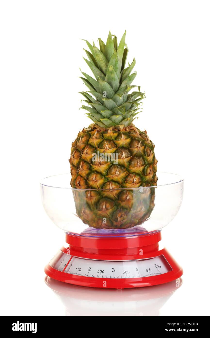 Ripe pineapple in kitchen scales isolated on white Stock Photo - Alamy