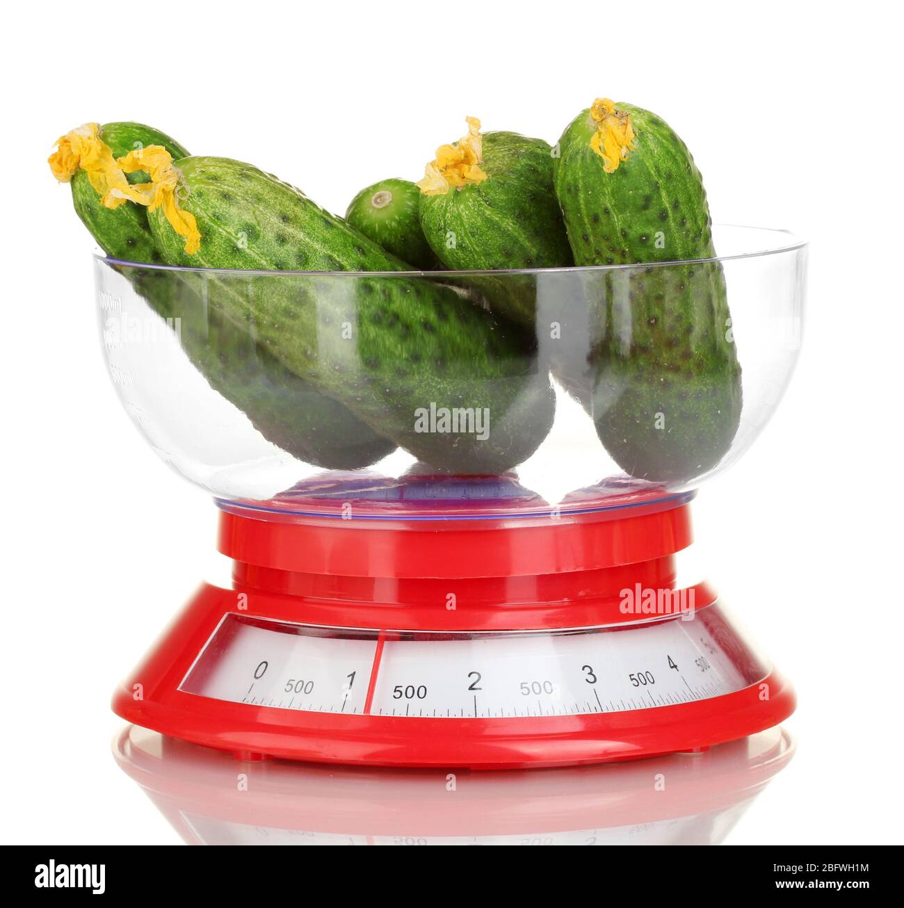 Fresh cucumbers in a kitchen scales isolated on white Stock Photo - Alamy