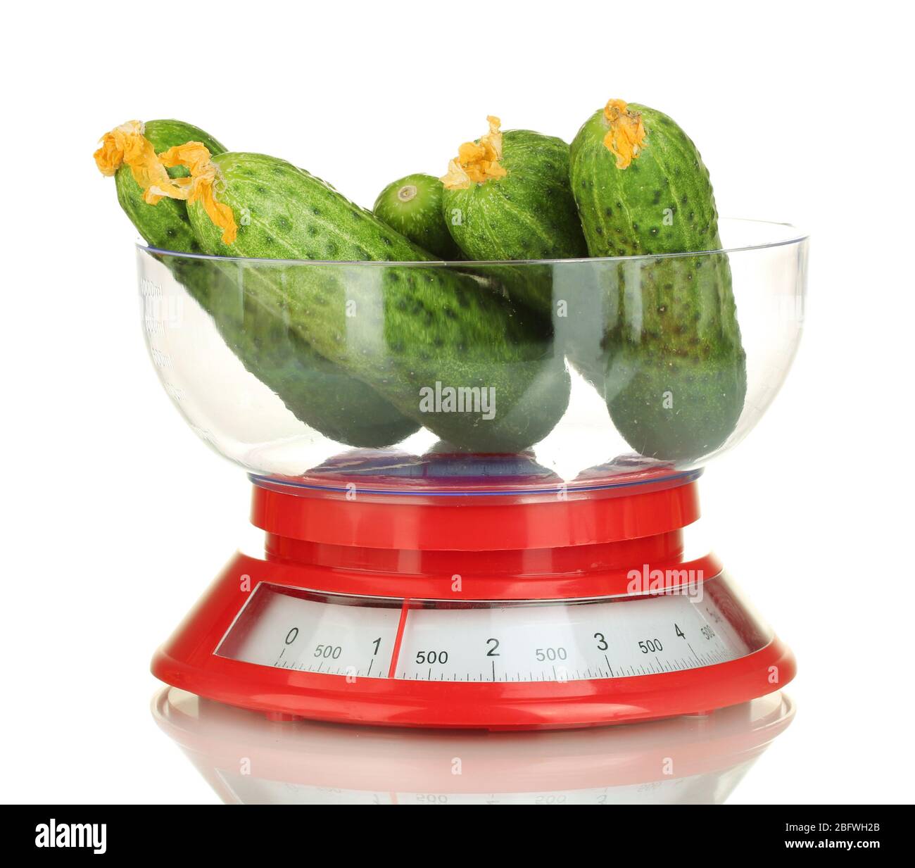 Fresh cucumbers in a kitchen scales isolated on white Stock Photo - Alamy