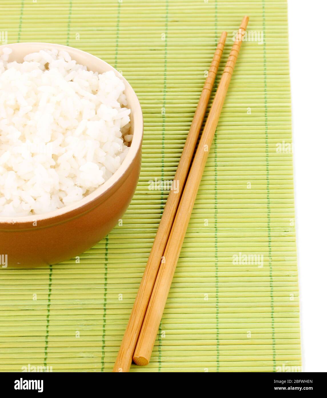 Bowl of rice and chopsticks on bamboo mat isolated on white Stock Photo ...