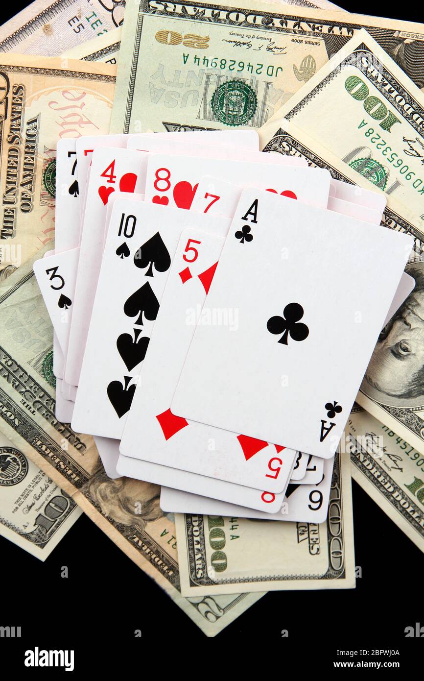 Dollars and a deck of playing cards on black background close-up Stock ...
