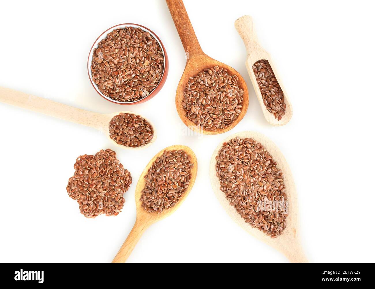 flax seeds in wooden spoons on white background close-up Stock Photo - Alamy