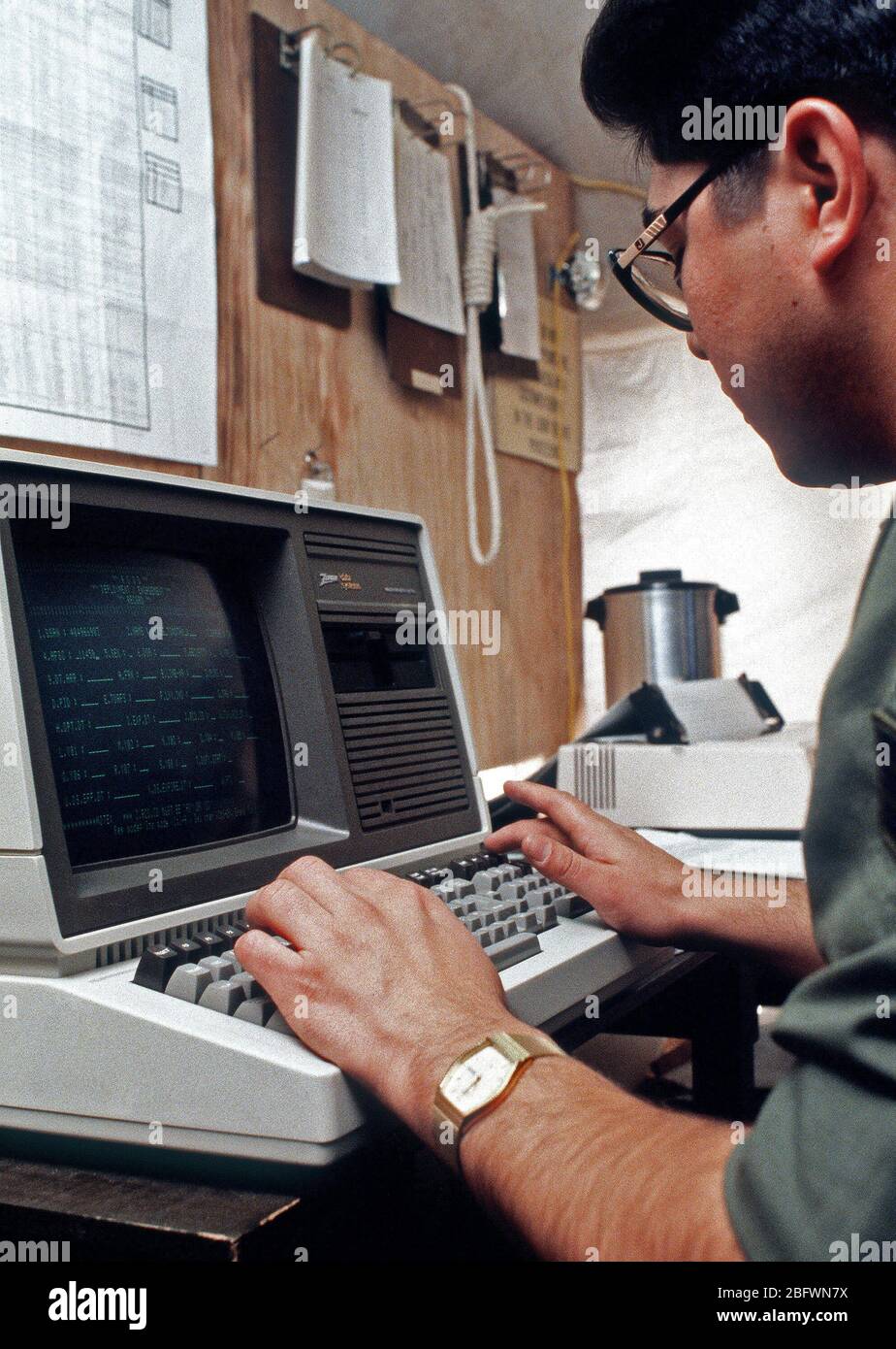 A personnel company Airman references data on a computer terminal ...