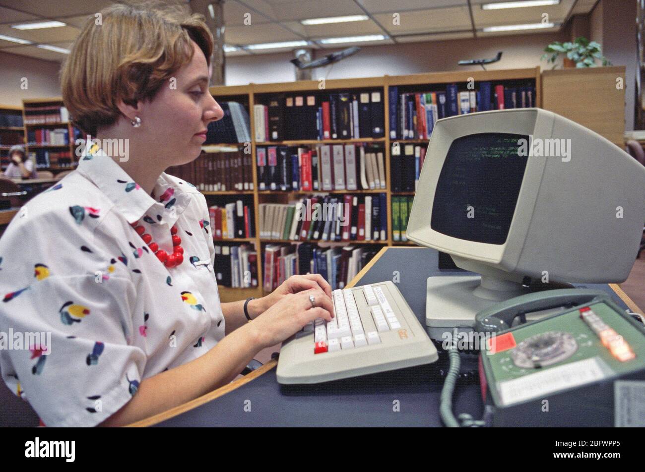 1987 - A reference librarian, inputs data into a computer at Fairchild ...