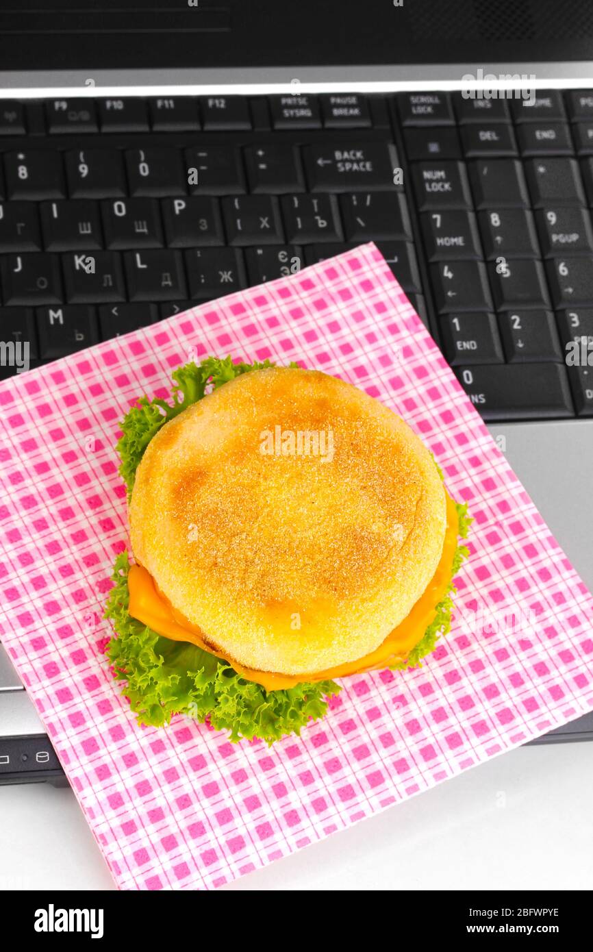Eating at work place near laptop Stock Photo - Alamy
