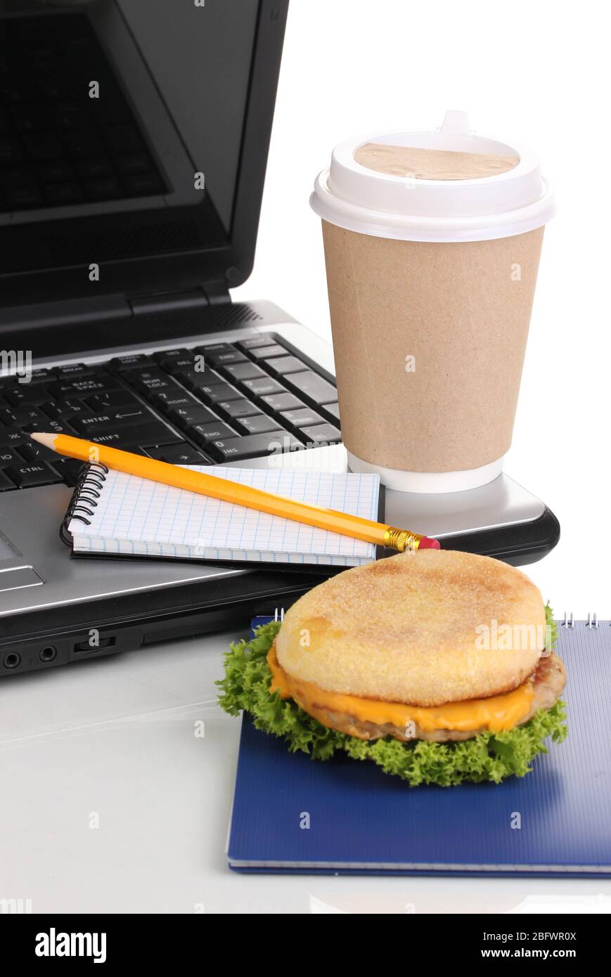 Eating at work place near laptop Stock Photo - Alamy