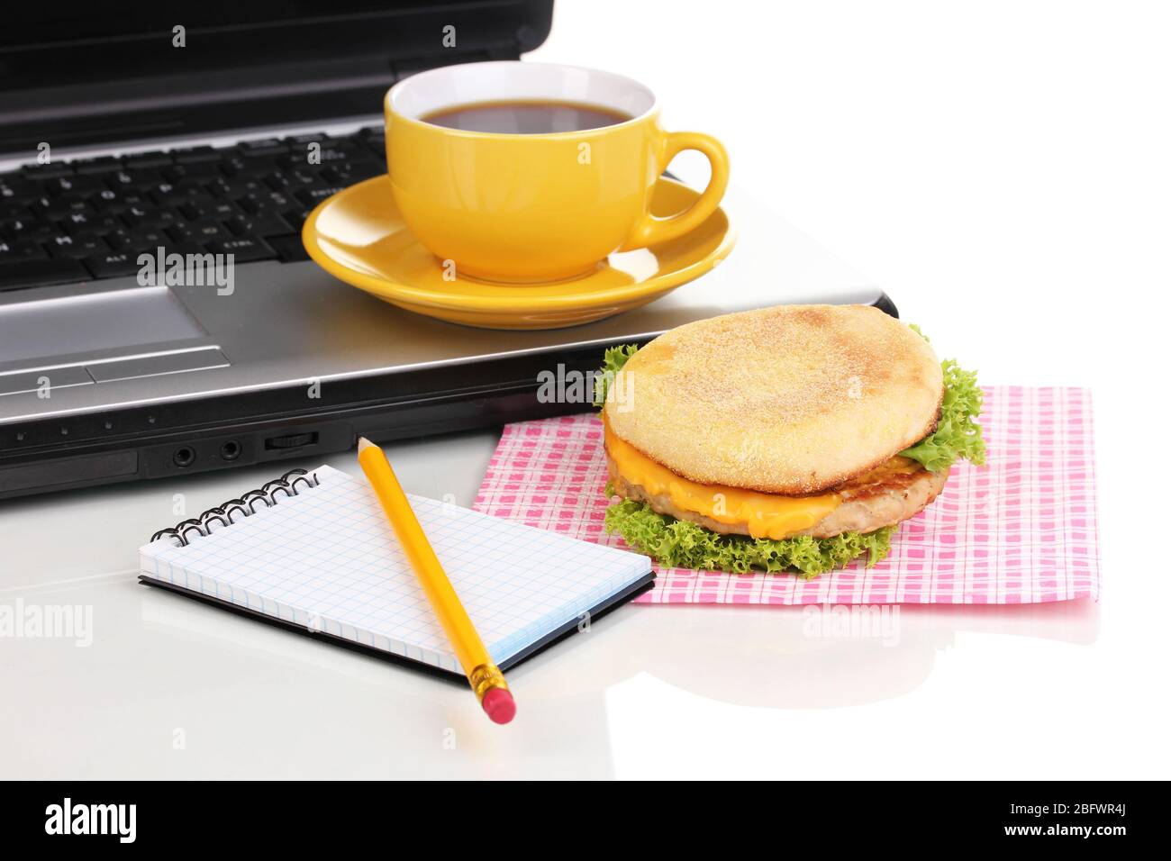 Eating at work place near laptop Stock Photo - Alamy