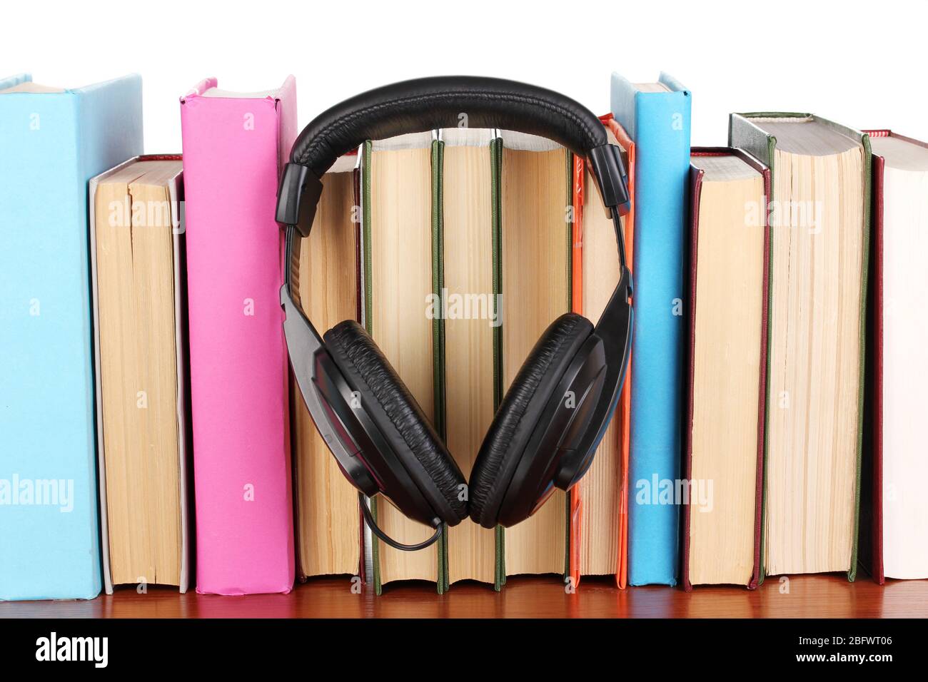 Headphones on books on wooden table on white background Stock Photo - Alamy