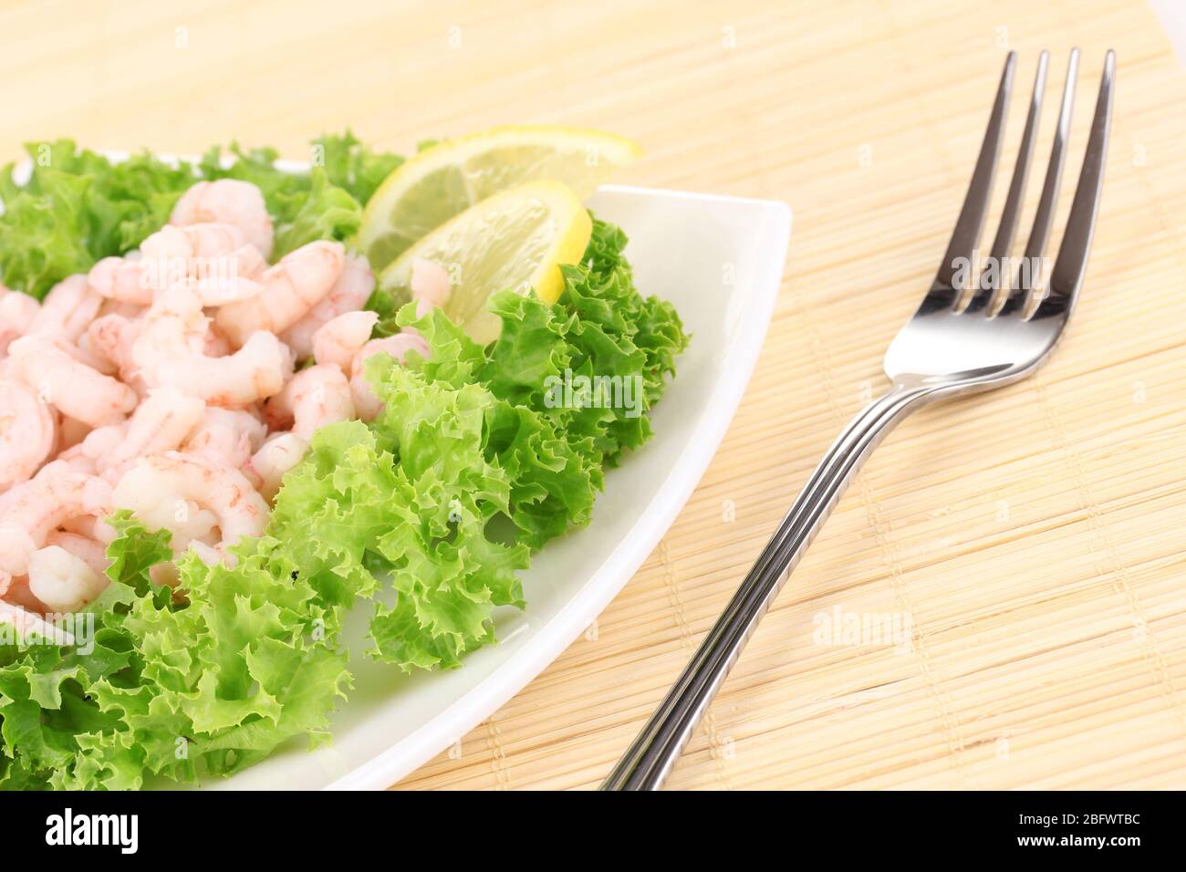 Delicious marinated shrimp in plate on bamboo mat Stock Photo - Alamy