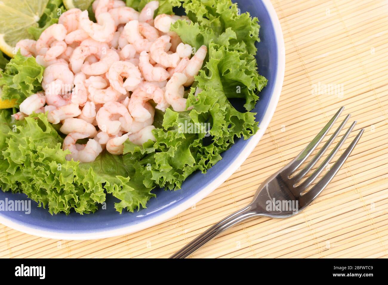 Delicious marinated shrimp in plate on bamboo mat Stock Photo - Alamy