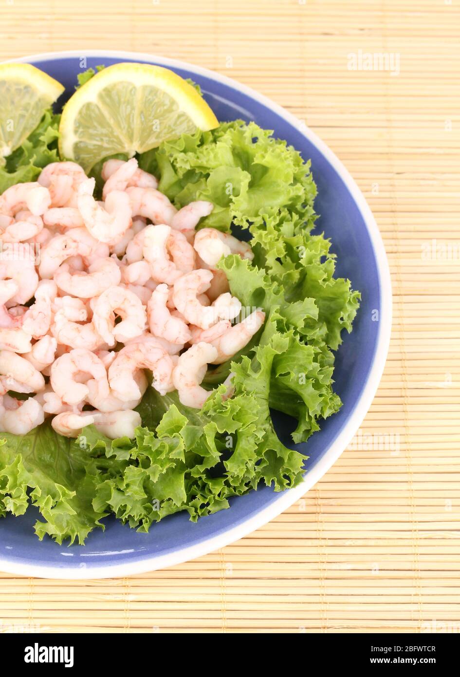 Delicious marinated shrimp in plate on bamboo mat Stock Photo - Alamy