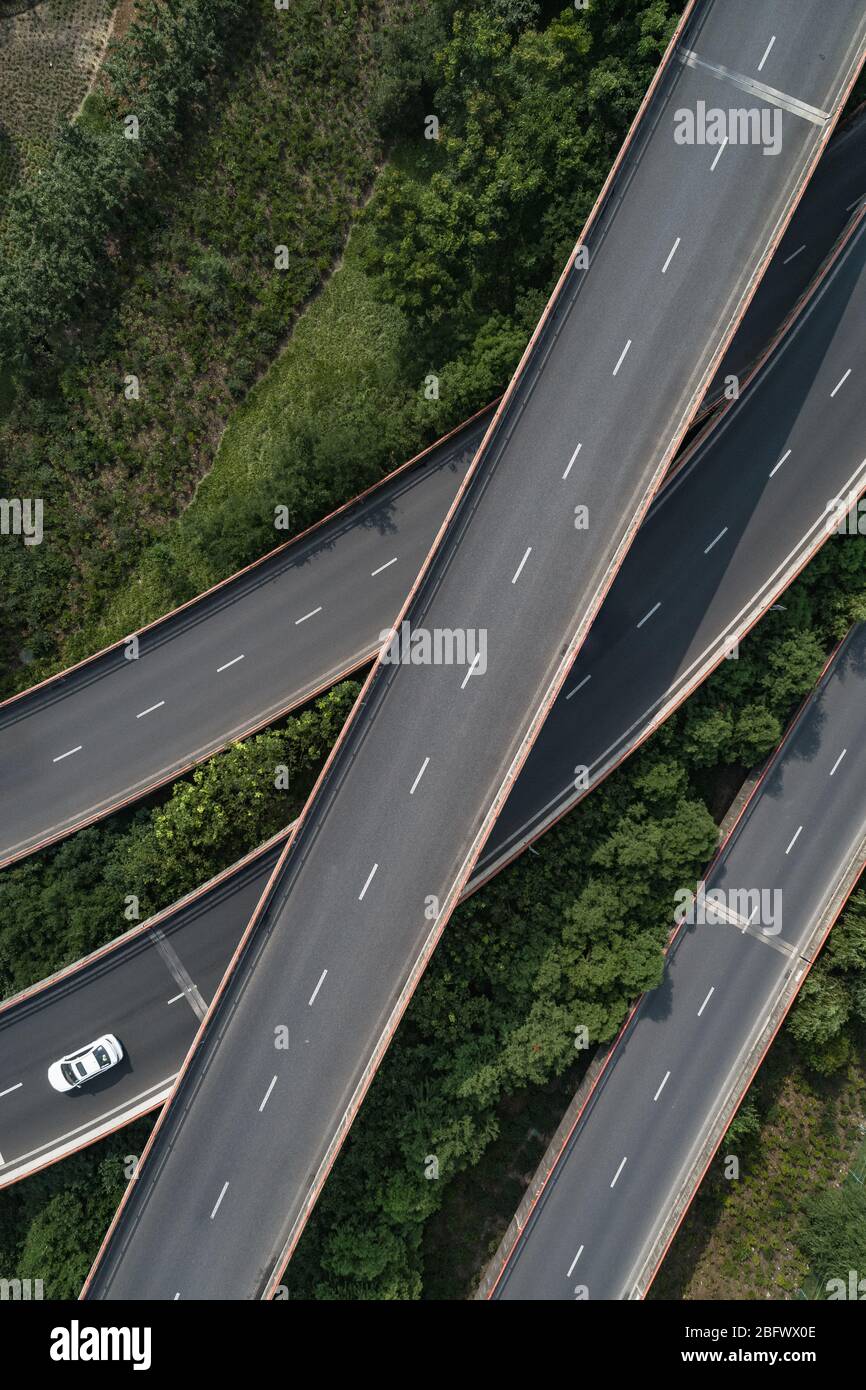 Aerial view of single car driving on highway and overpass Stock Photo ...