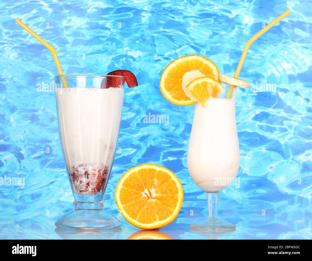 Delicious milk shake with fruit on table on blue sea background Stock ...