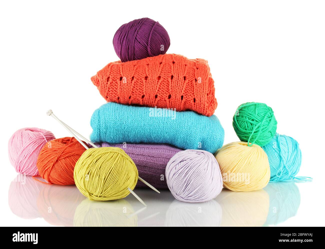 Sweaters and balls of wool isolated on white Stock Photo - Alamy