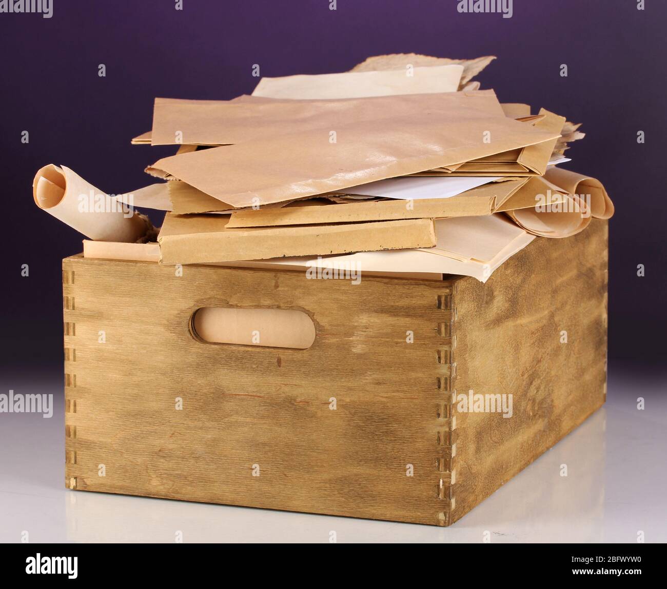 Wooden crate with papers and letters on purple background Stock Photo ...
