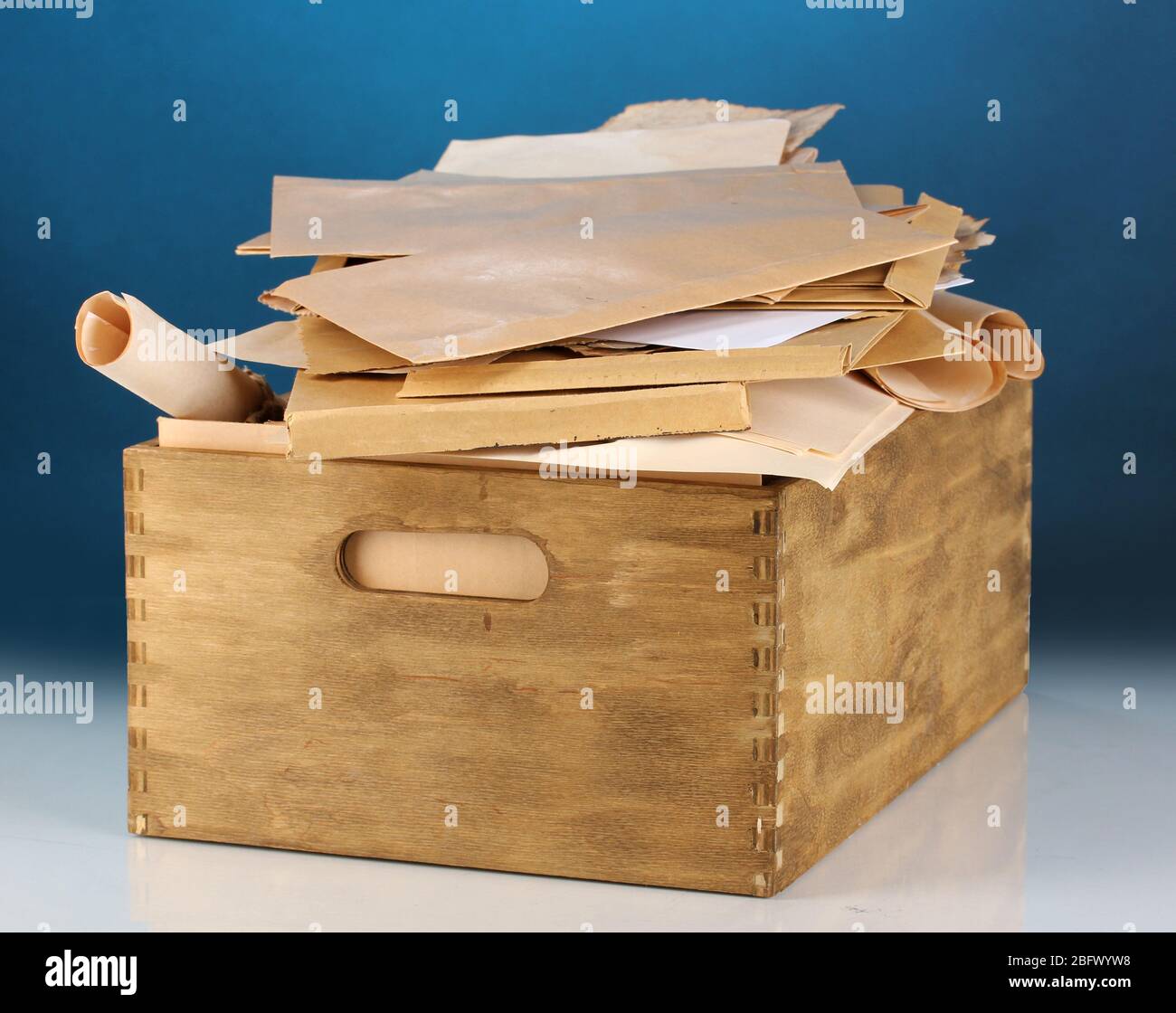 Wooden crate with papers and letters on blue background Stock Photo - Alamy