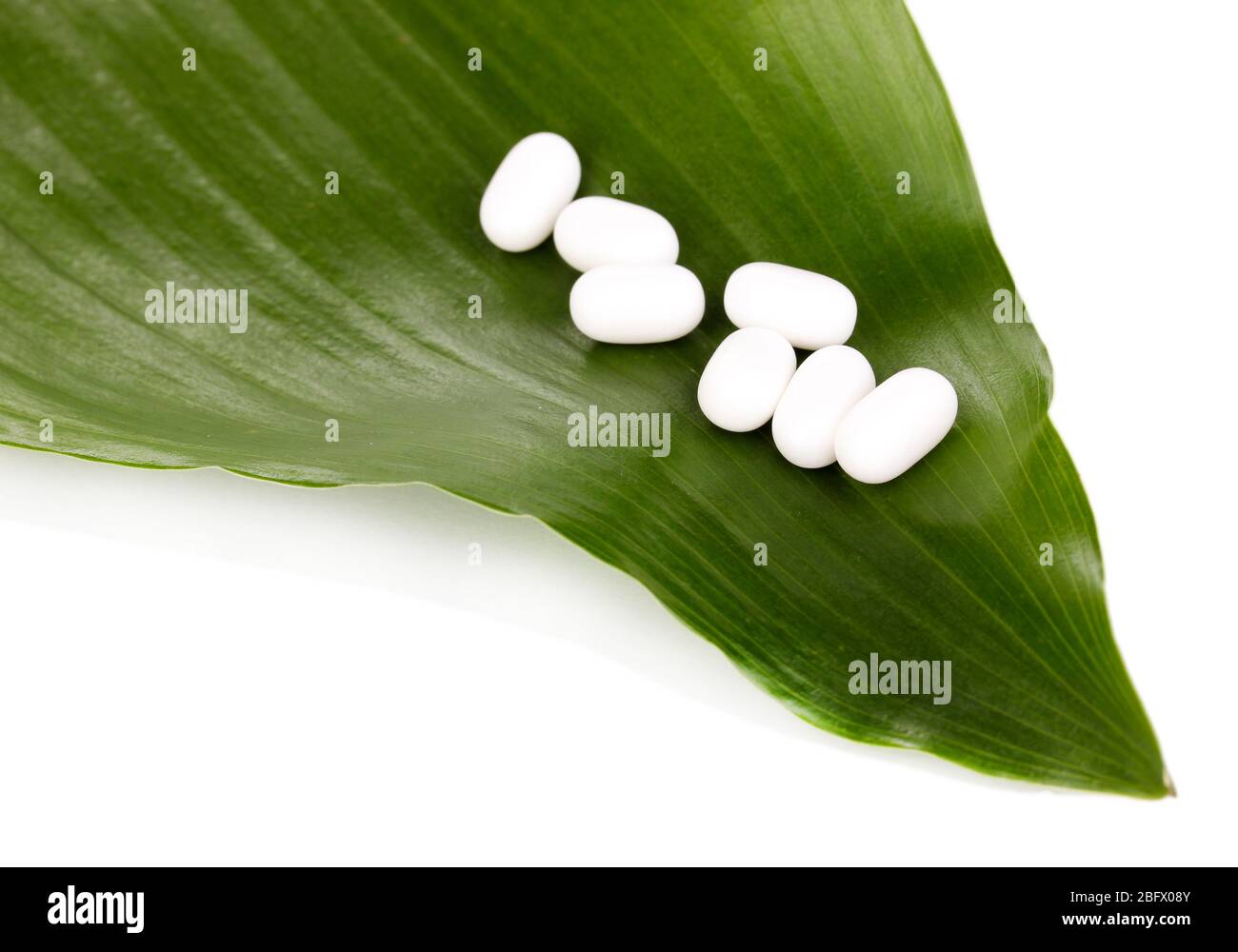 tablets on green leaf isolated on white Stock Photo - Alamy