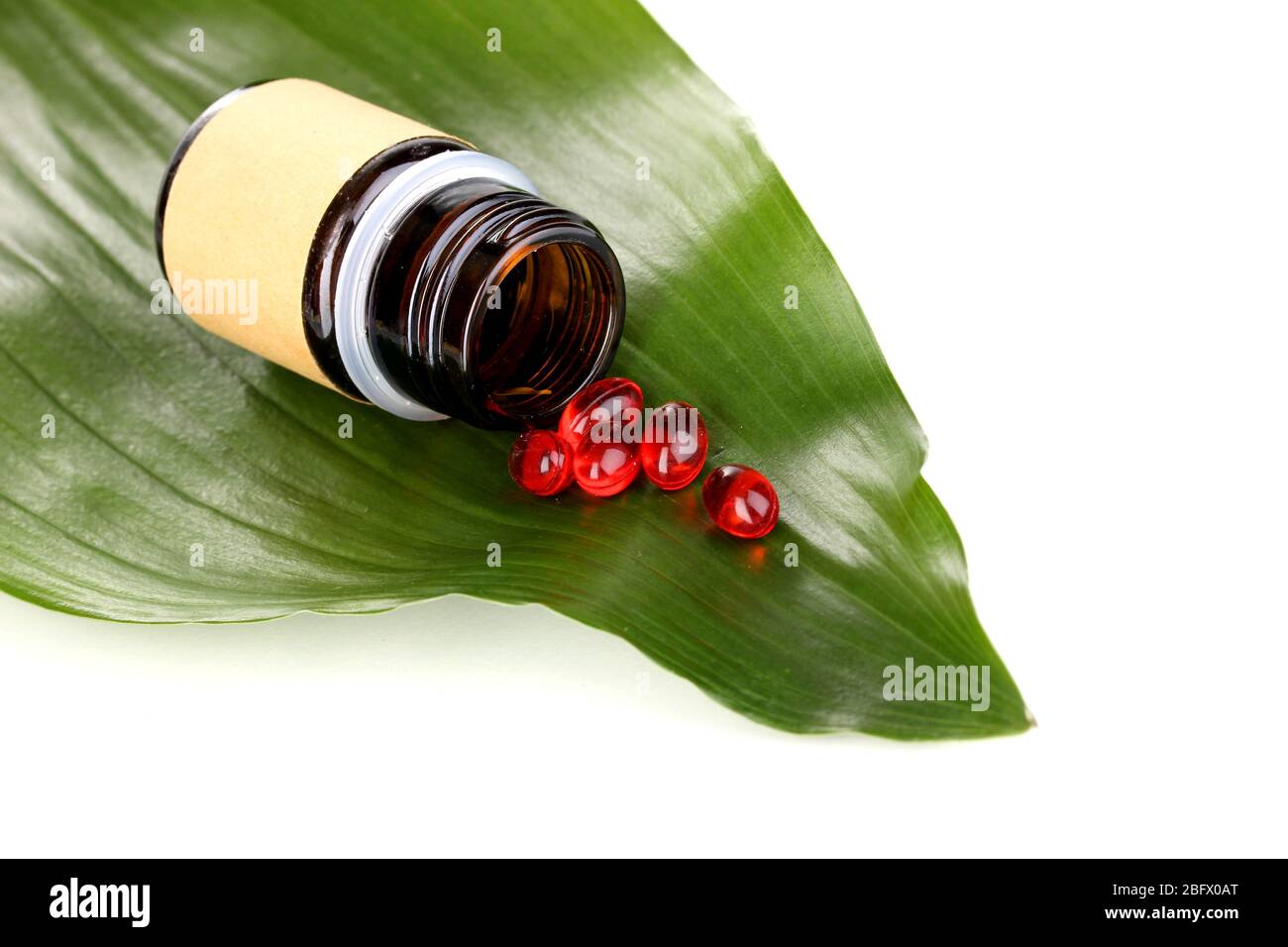 tablets on green leaf with bottle isolated on white Stock Photo - Alamy