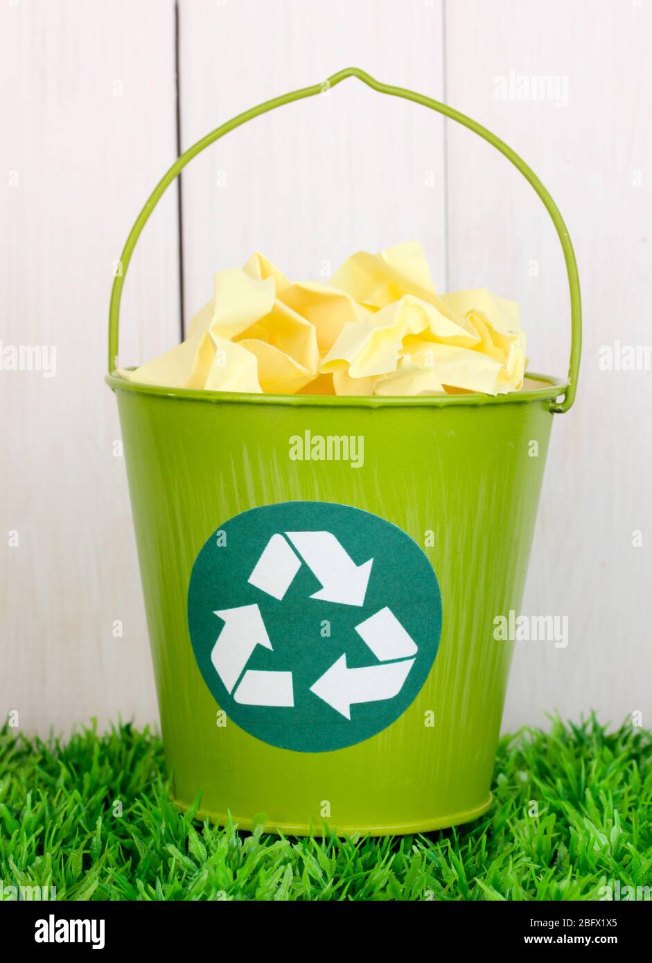 Recycling bin on green grass near wooden fence Stock Photo - Alamy