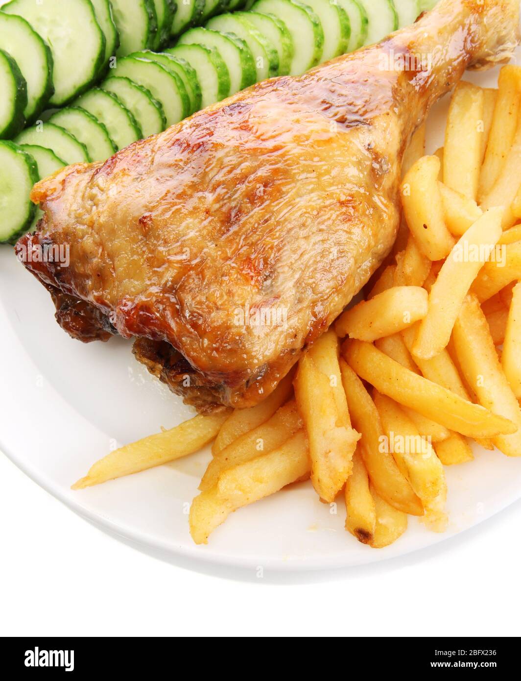 Roast chicken with french fries and cucumbers on plate, isolated on ...