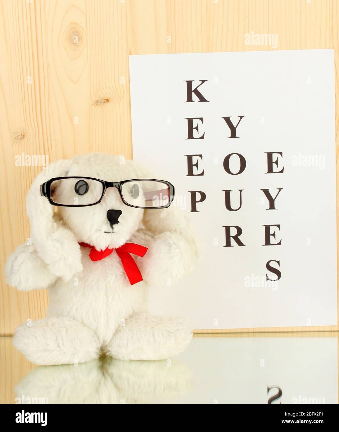Eyesight test chart with glasses and with toy on wooden background ...