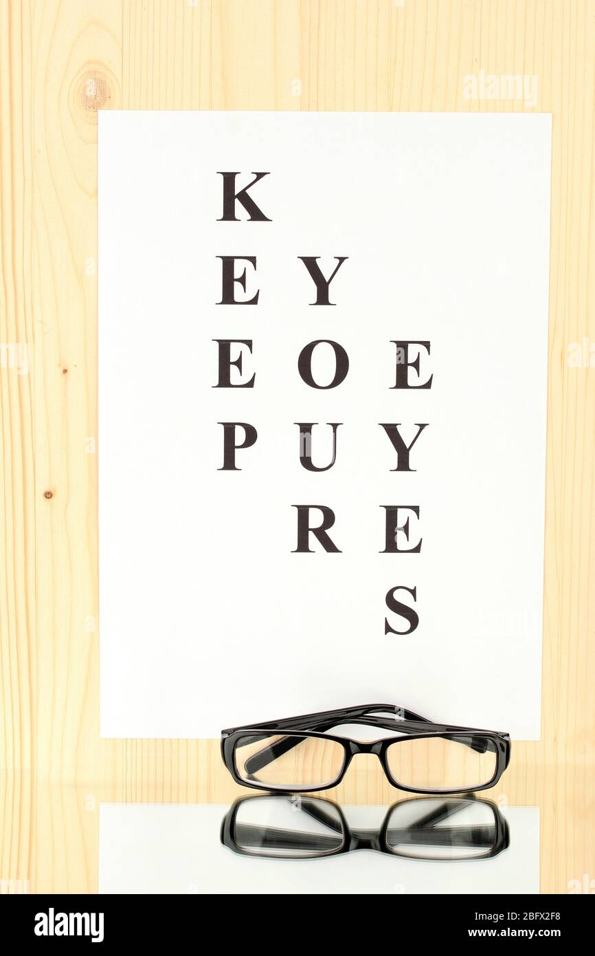 Eyesight test chart with glasses on wooden background close-up Stock ...