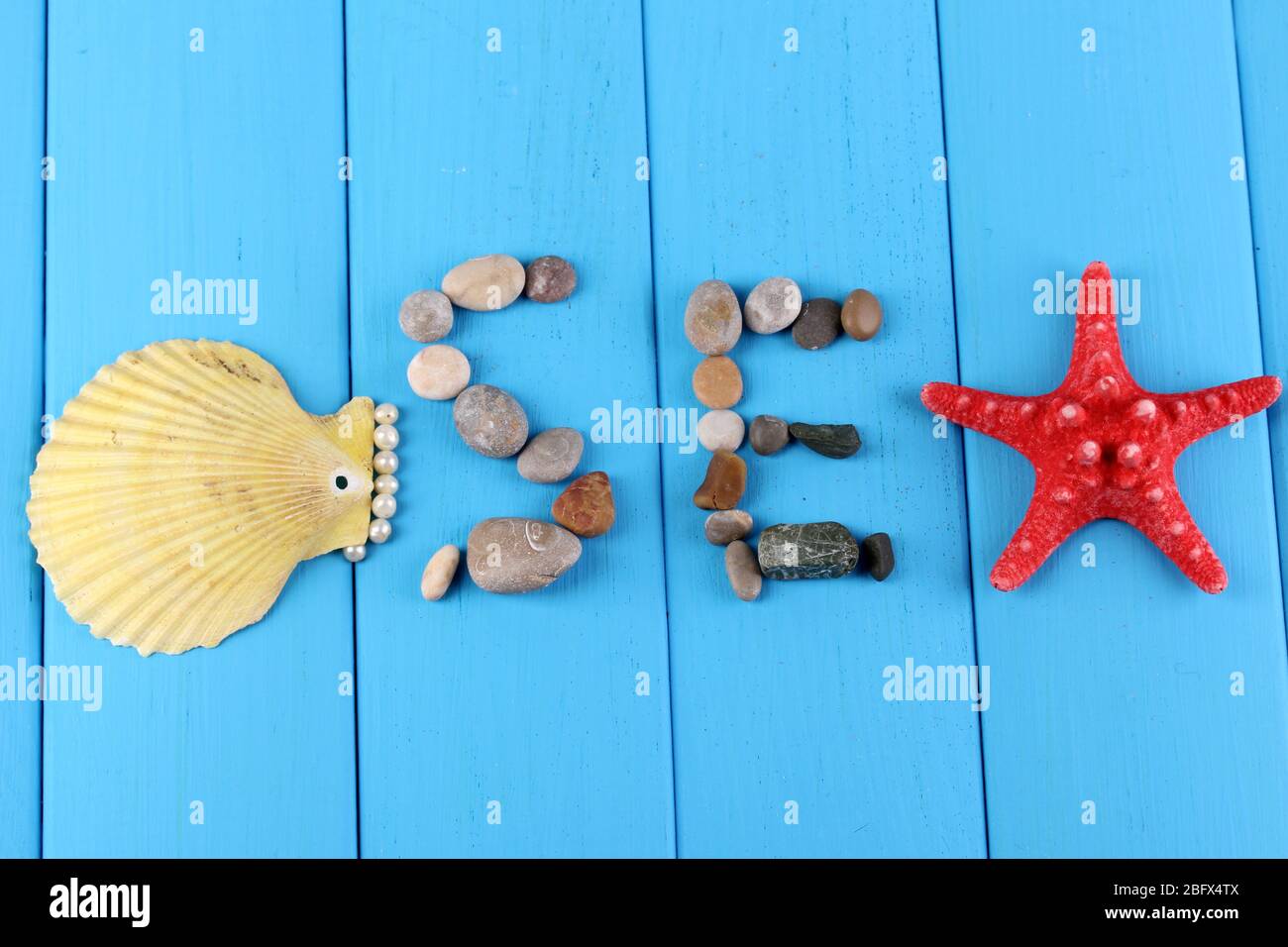 The word sea and decor of seashells close-up on blue wooden table Stock ...