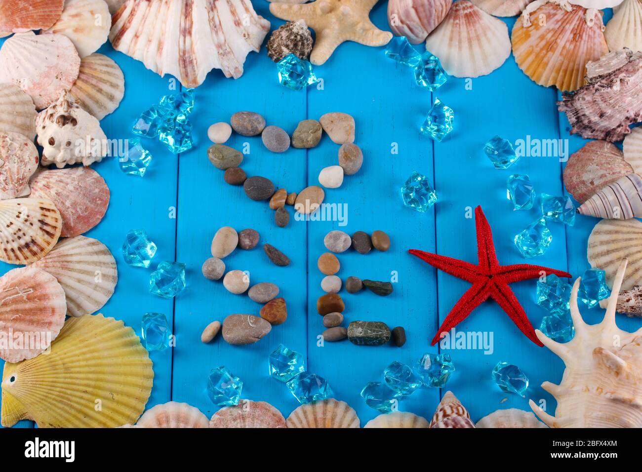 The word sea and decor of seashells close-up on blue wooden table Stock ...