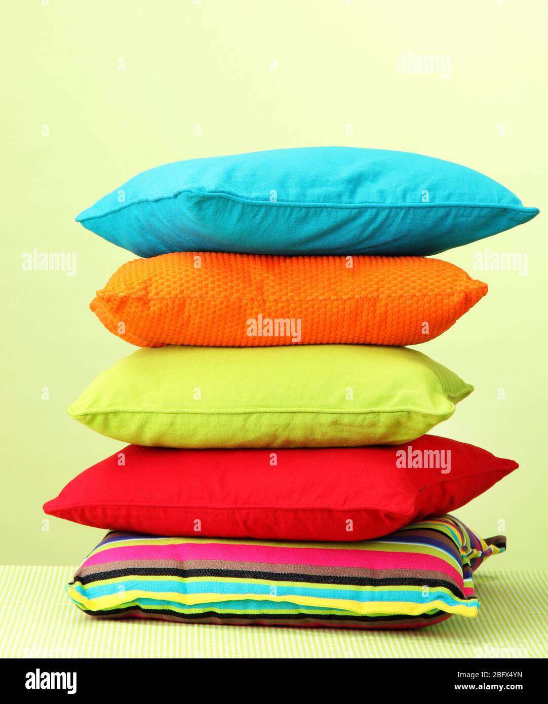 Colorful pillows on yellow background Stock Photo - Alamy