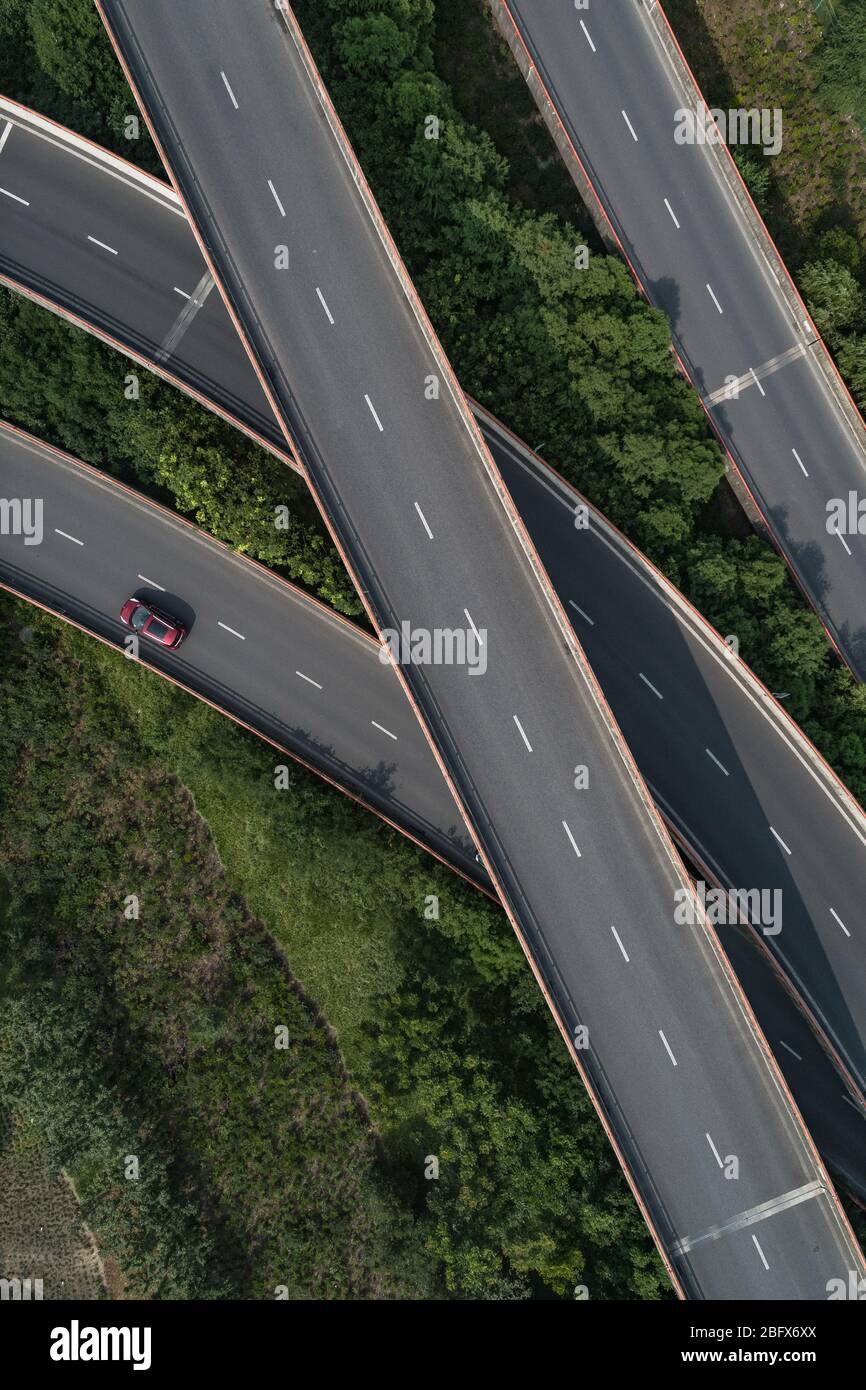 Aerial view of single car driving on highway and overpass Stock Photo ...