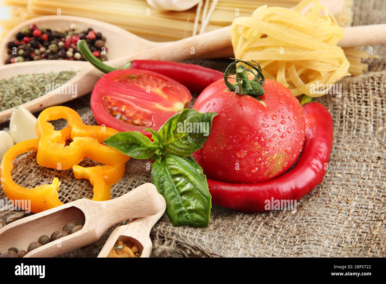 Pasta spaghetti, vegetables and spices, on sacking background Stock ...
